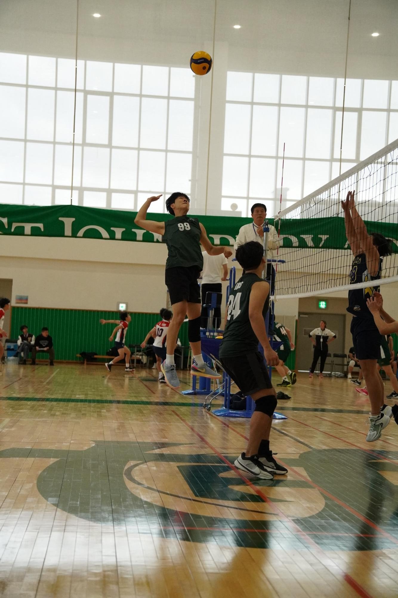 Colin Ji (number 99) rises up to spike the ball through the BFS ...